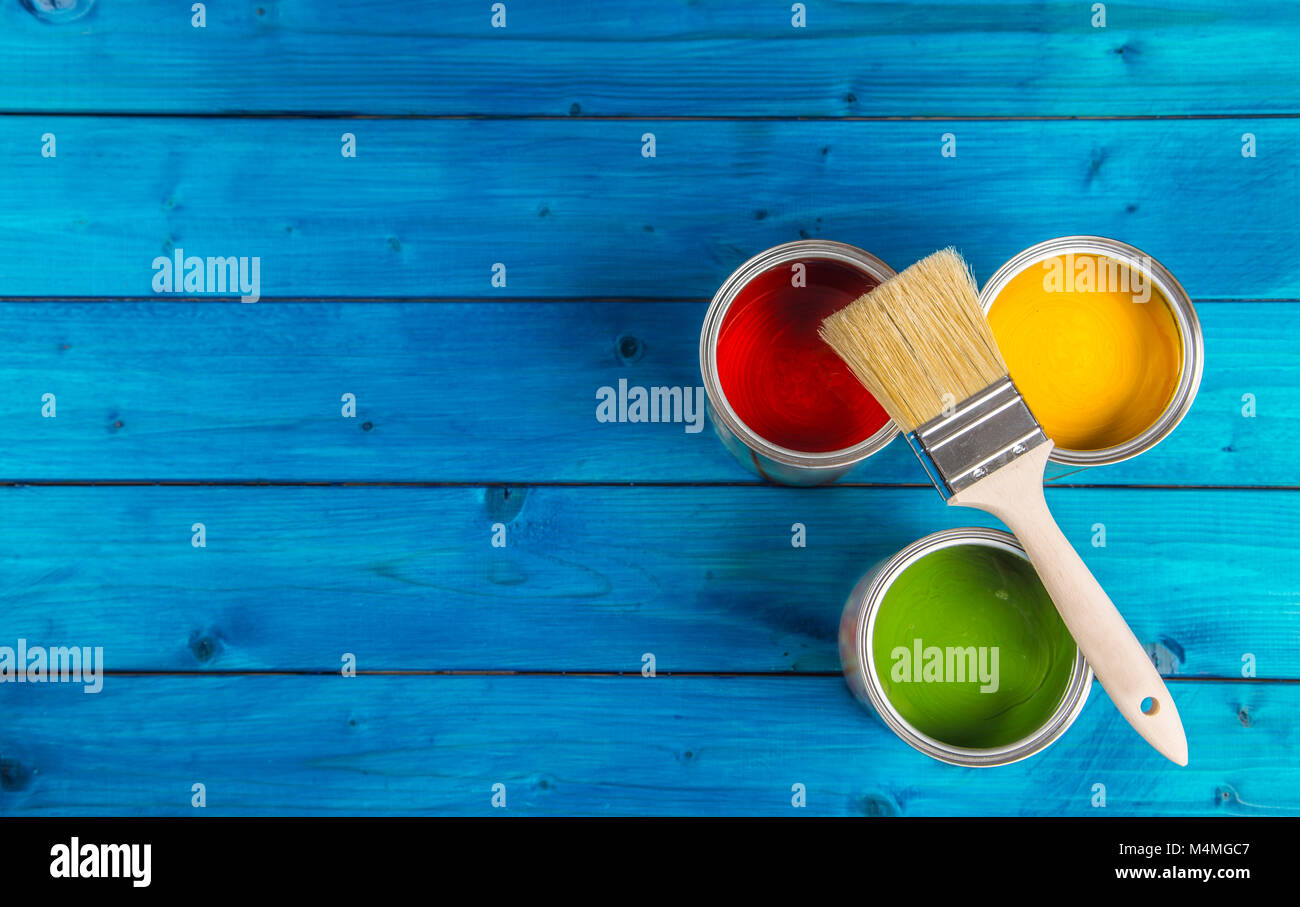Paint cans color palette, cans opened with brushes on blue table Stock ...