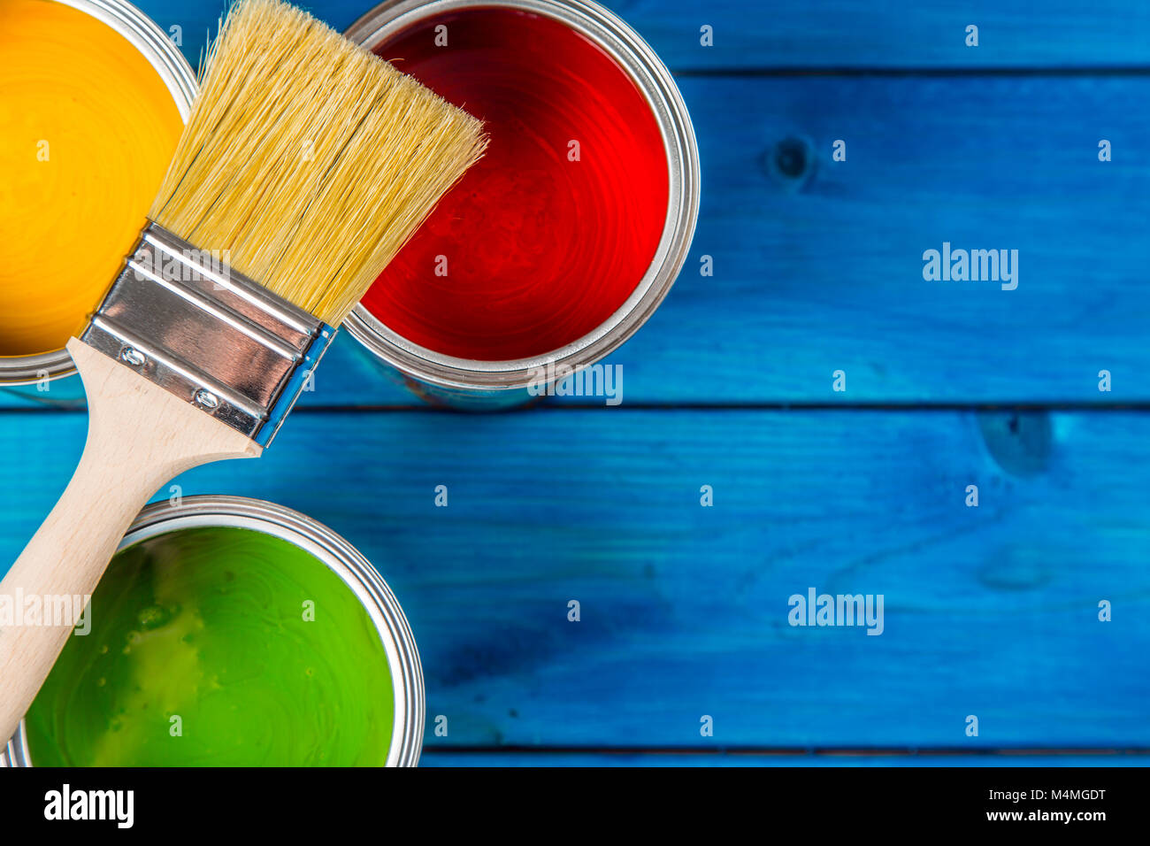 Paint cans color palette, cans opened with brushes on blue table Stock ...