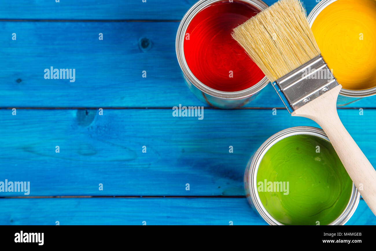 Paint cans color palette, cans opened with brushes on blue table Stock ...