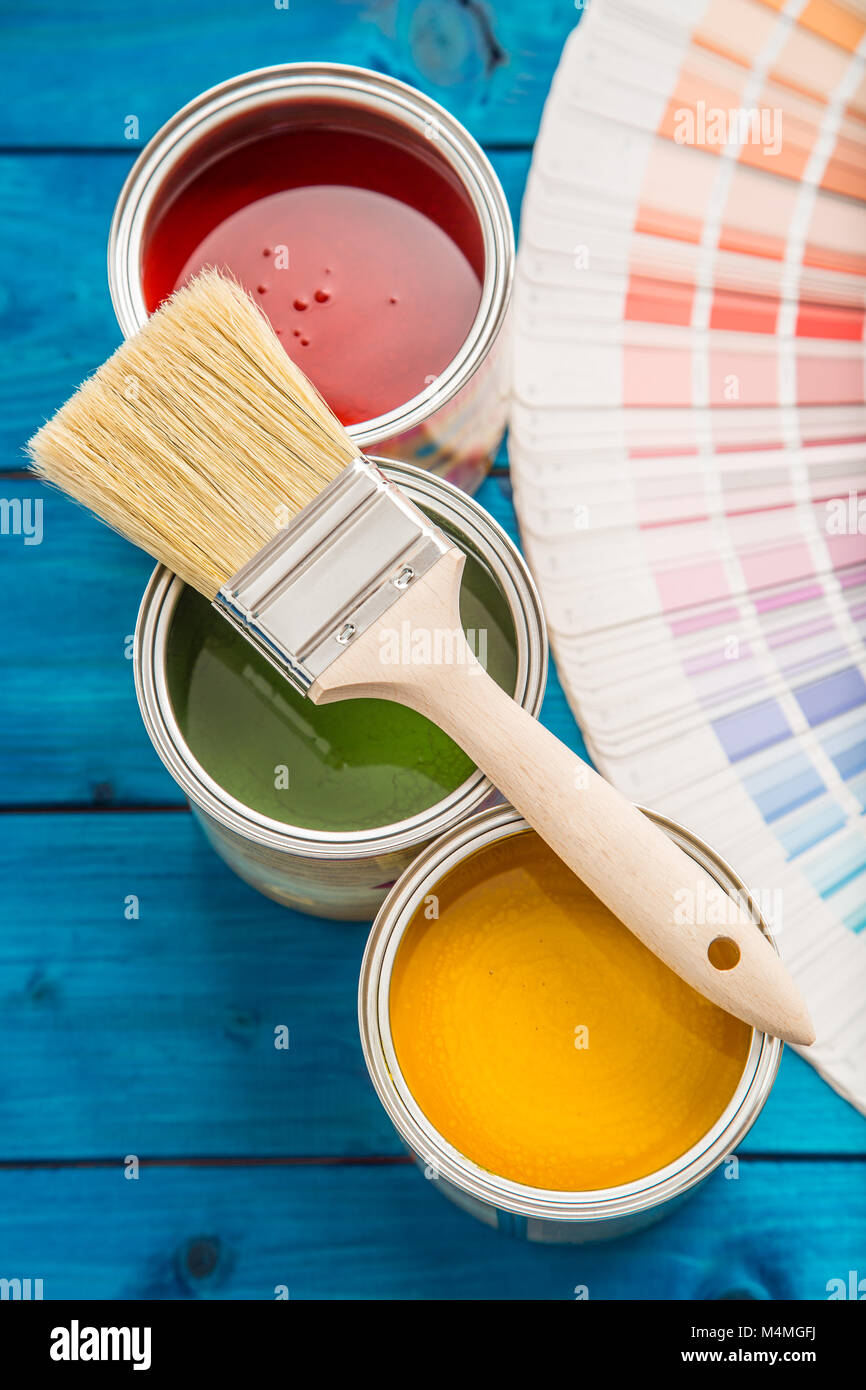 Paint cans color palette, cans opened with brushes on blue table Stock ...