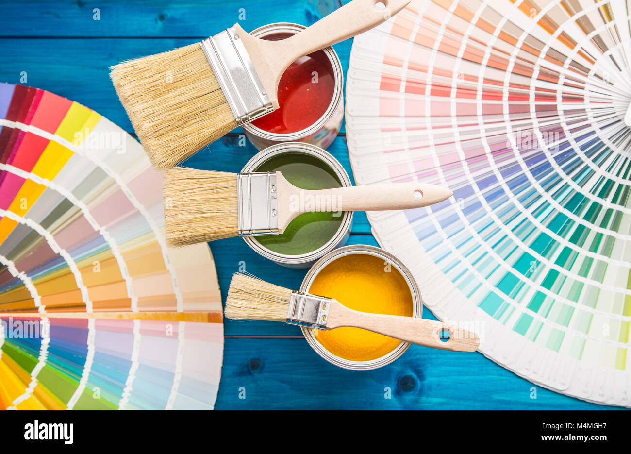 Paint cans color palette, cans opened with brushes on blue table Stock ...
