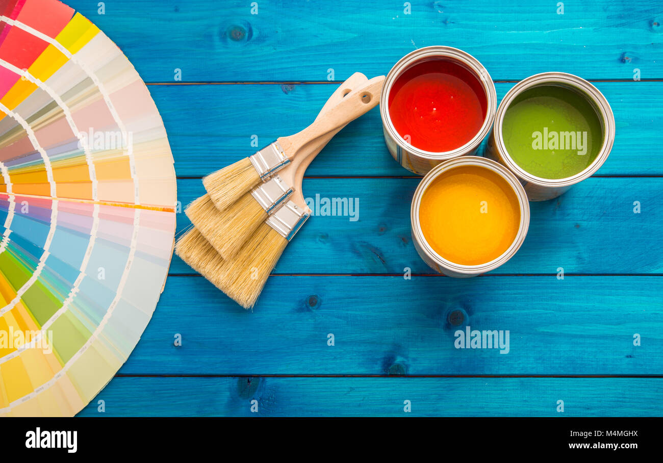 Paint cans color palette, cans opened with brushes on blue table Stock ...