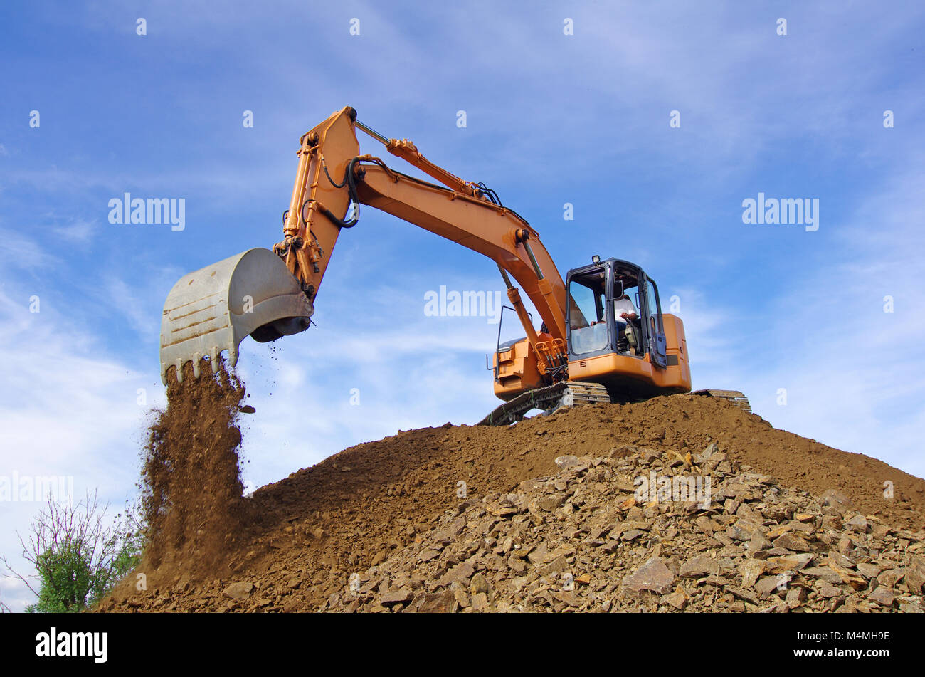 Excavator in action during earth moving works Stock Photo - Alamy