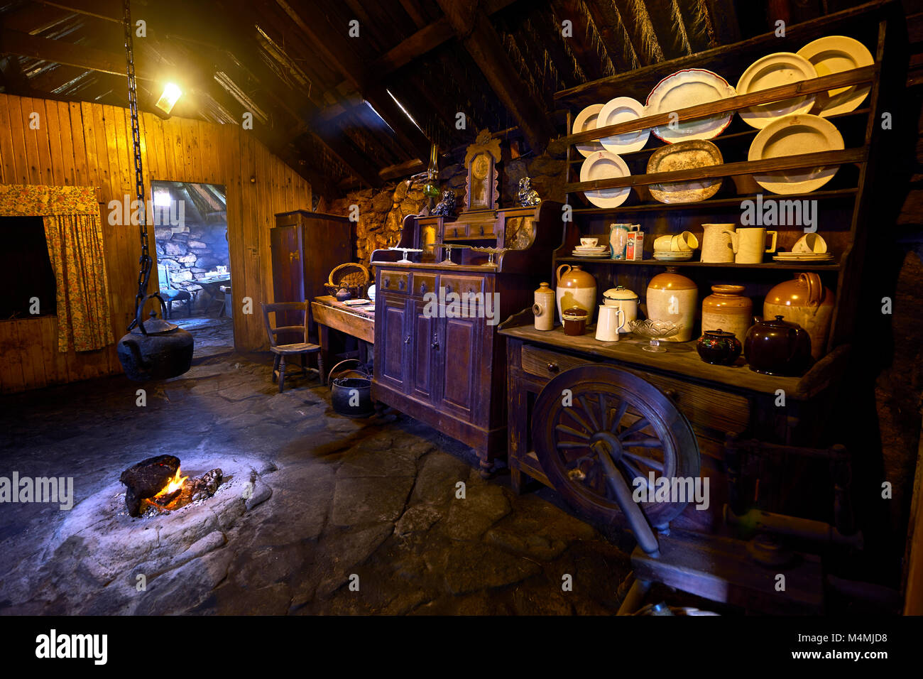 Original interior of the kitchen area with paet fire burning in The Blackhouse, 24 Arnol, Bragar ...