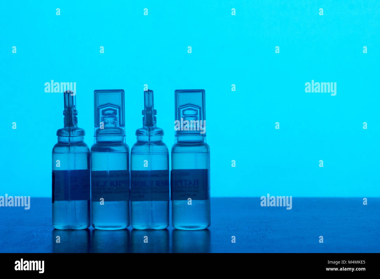 Plastic ampoules with solution for injections on the blue background ...