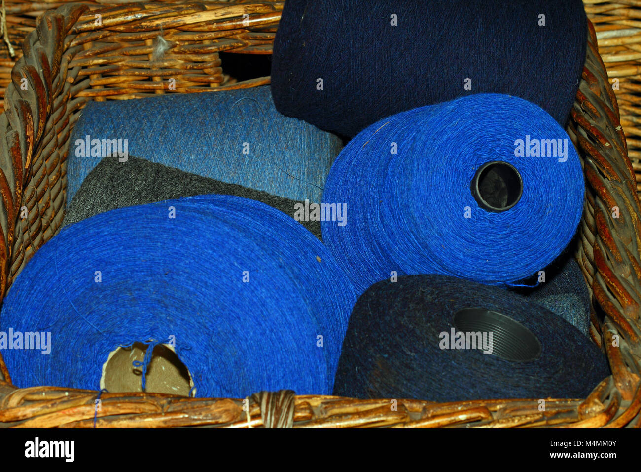 Large spools of blue yarn in a wicker basket Stock Photo - Alamy