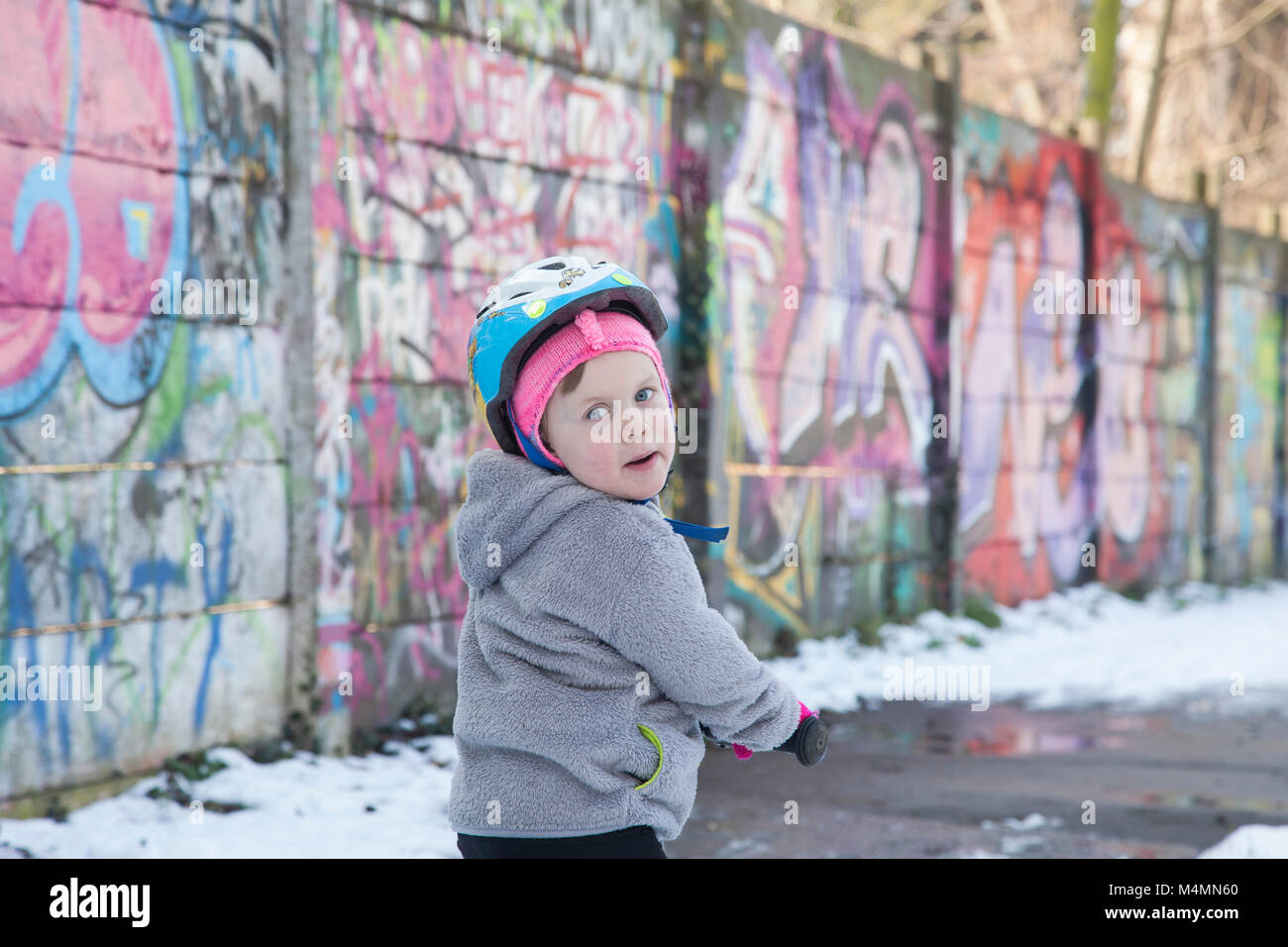 Happy little girl have fun in nature beside the graffiti wall and ...