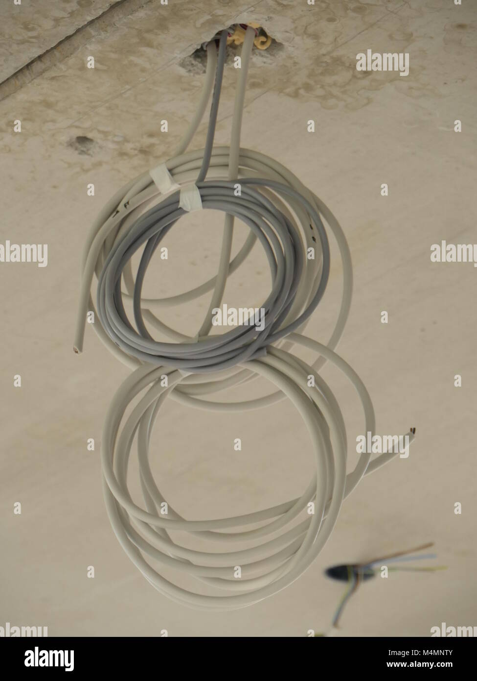 Two rolled wires sticking out of ceiling Stock Photo - Alamy