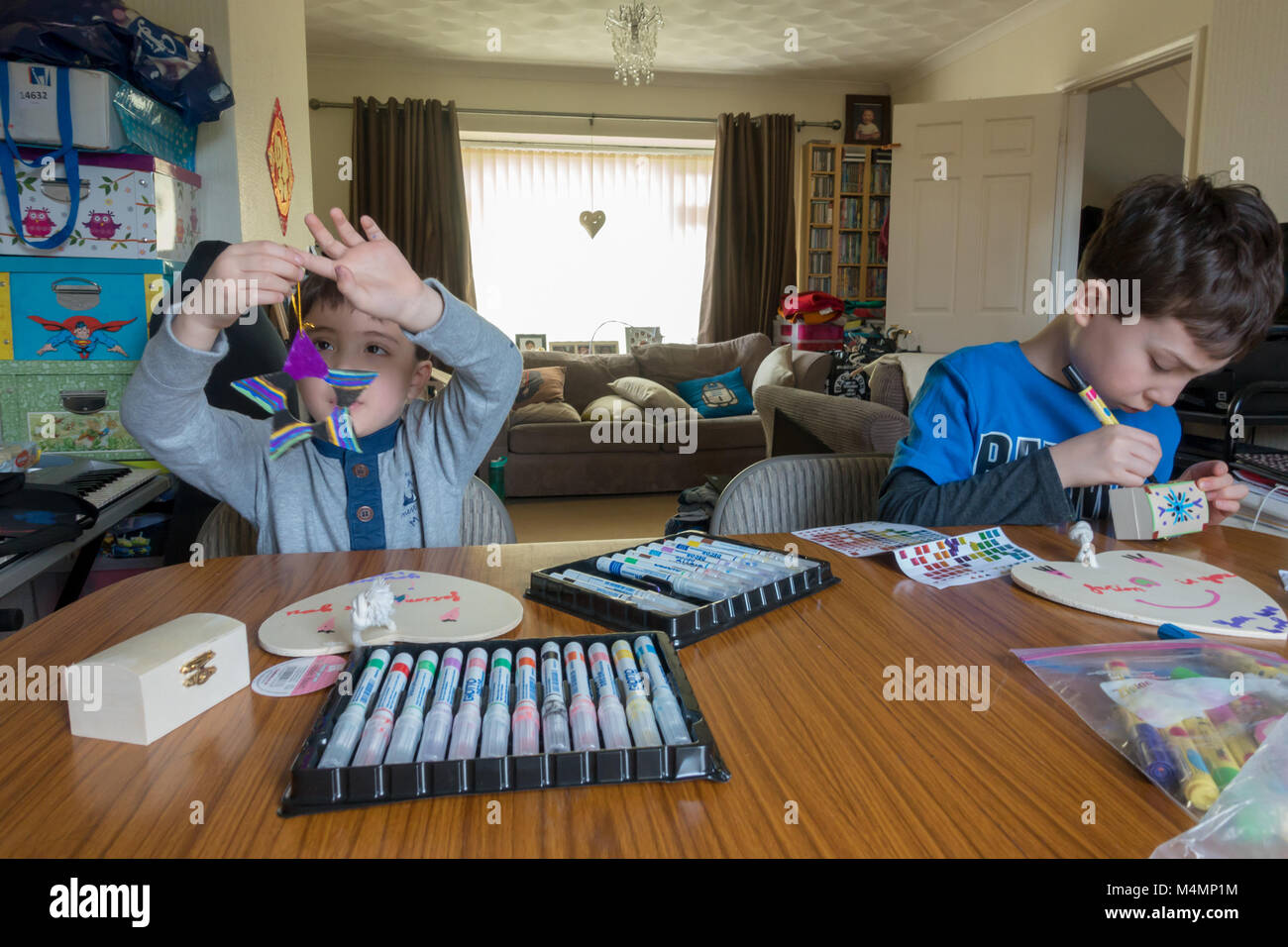 A young boys doing arts and crafts at home on the dining table Stock ...