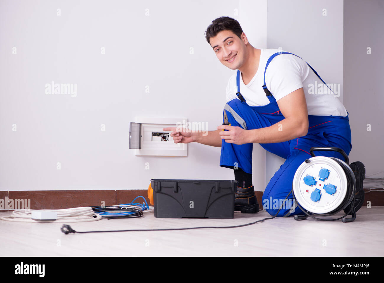 Young electrician working on socket at home Stock Photo - Alamy