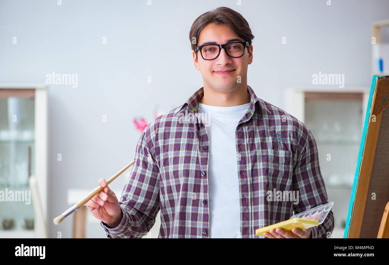 Young male artist drawing pictures in bright studio Stock Photo - Alamy