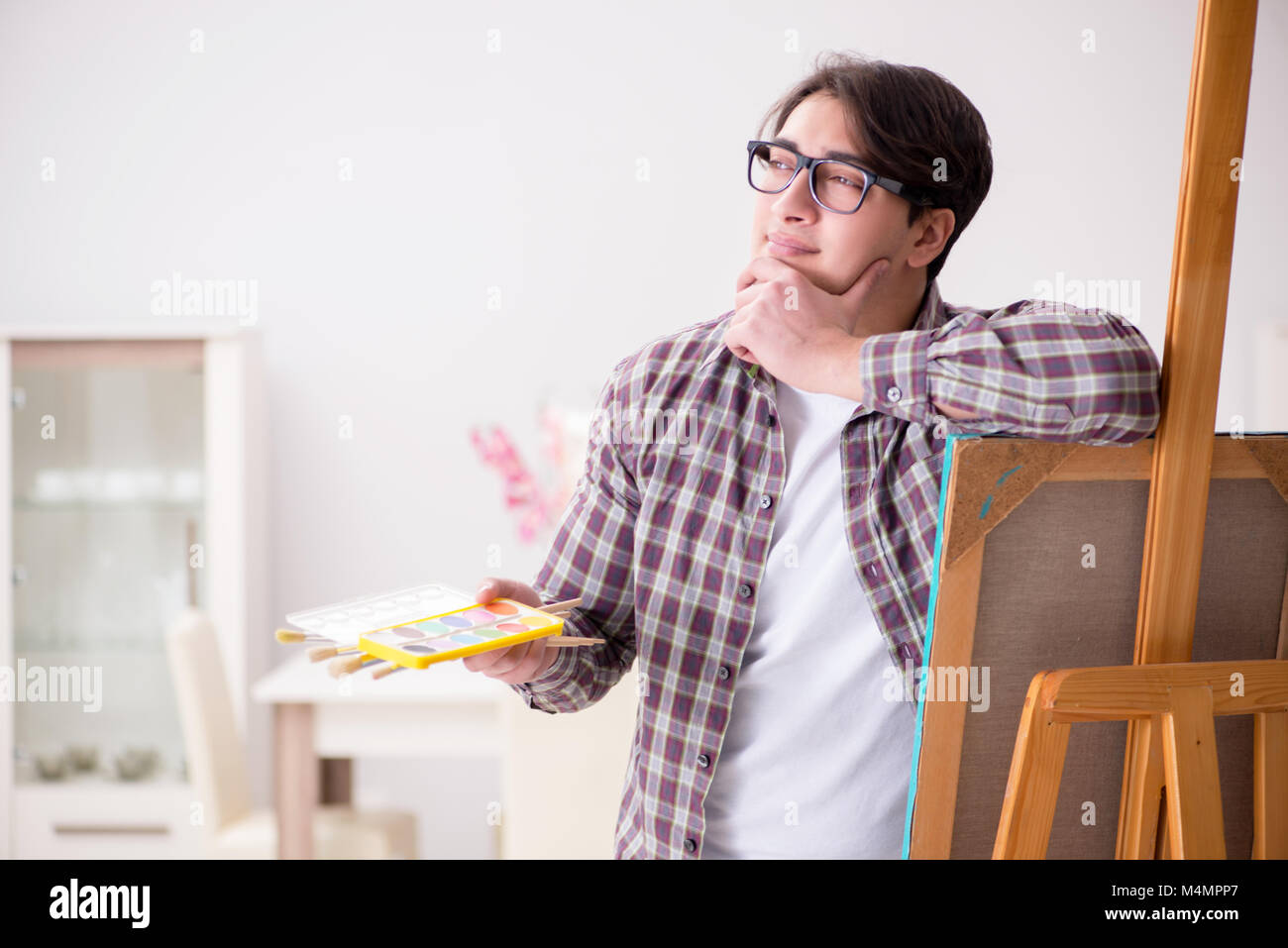 Young male artist drawing pictures in bright studio Stock Photo - Alamy