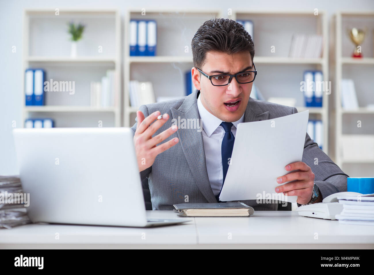 Businessman smoking in office at work Stock Photo - Alamy