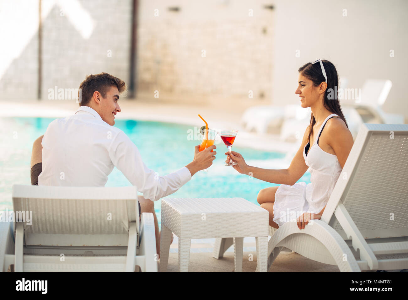 Positive happy couple having a romantic afternoon by the pool in luxury ...