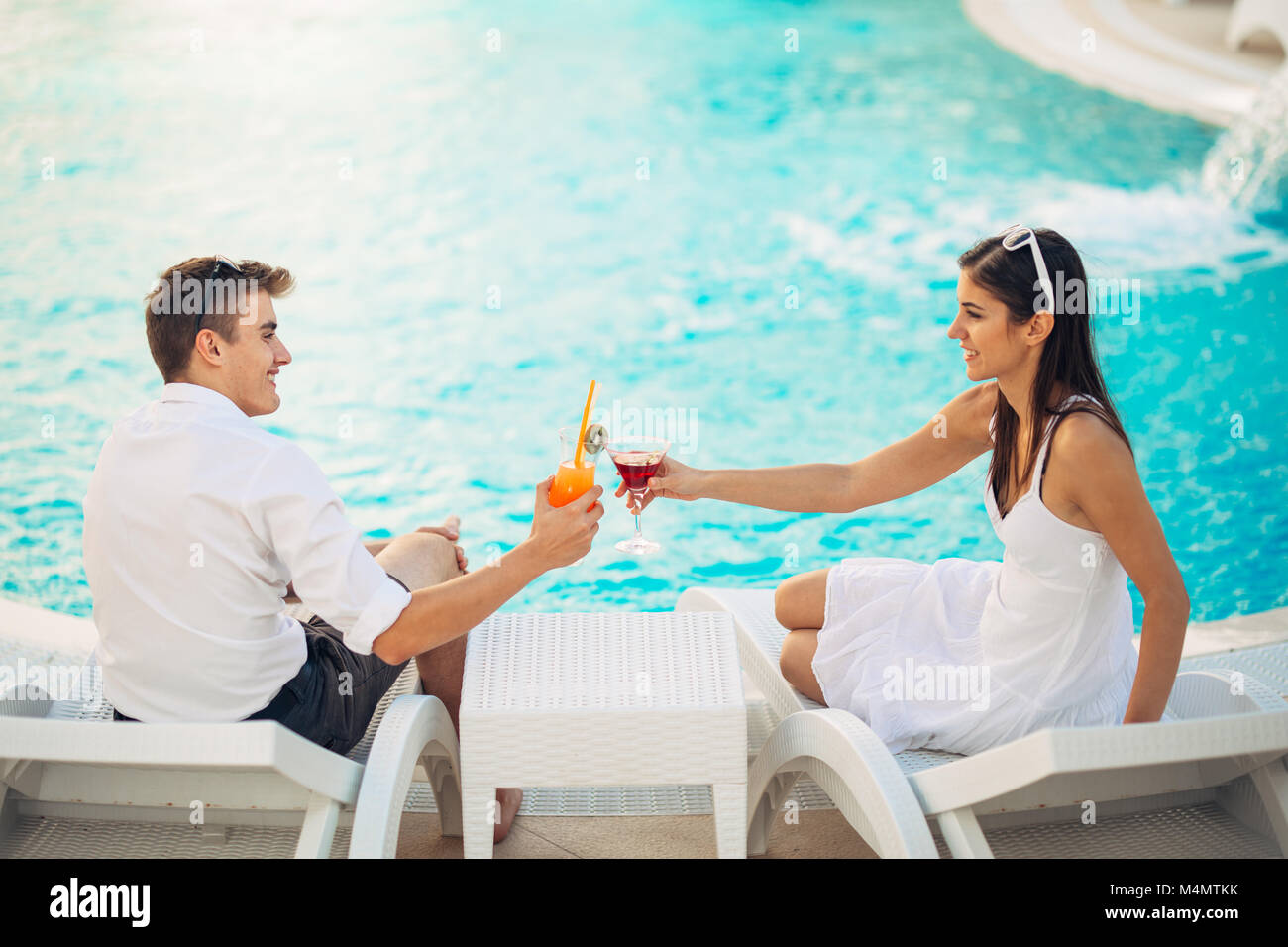 Romantic couple relaxing by swimming pool hi-res stock photography and ...