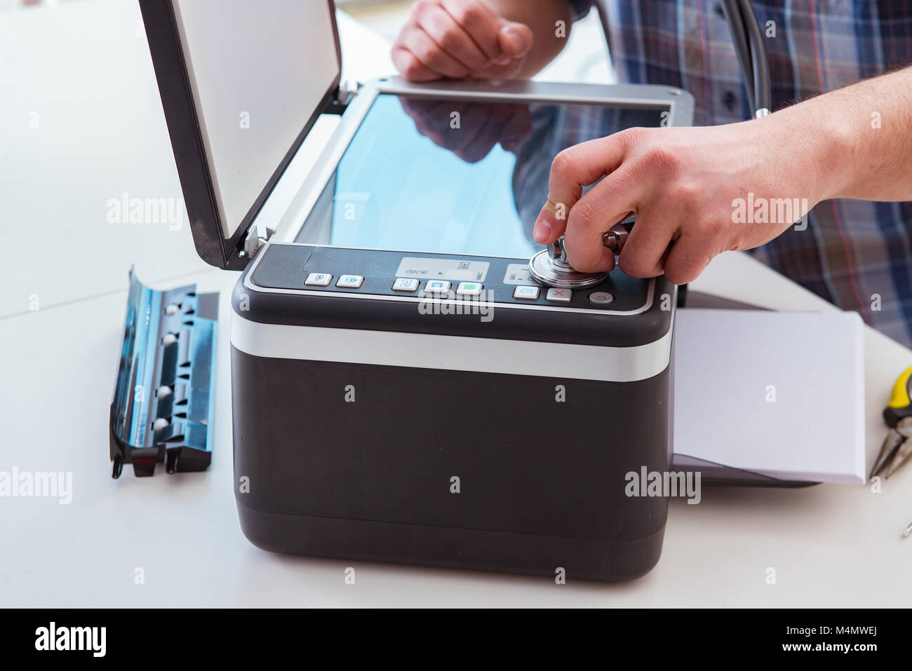 Repairman repairing broken color printer Stock Photo - Alamy