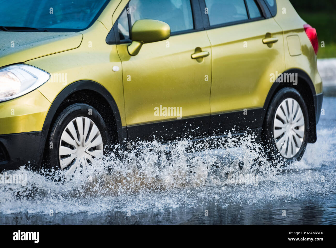 car rain puddle splashing water Stock Photo - Alamy