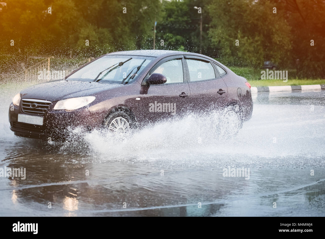 car rain puddle splashing water Stock Photo - Alamy