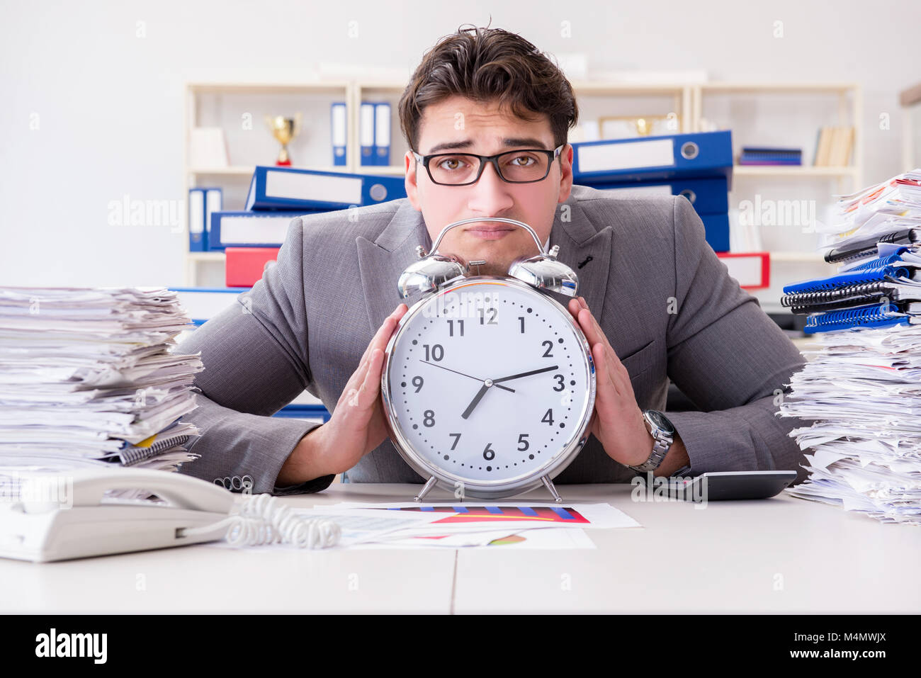 Businessman missing deadlines due to excessive work Stock Photo - Alamy