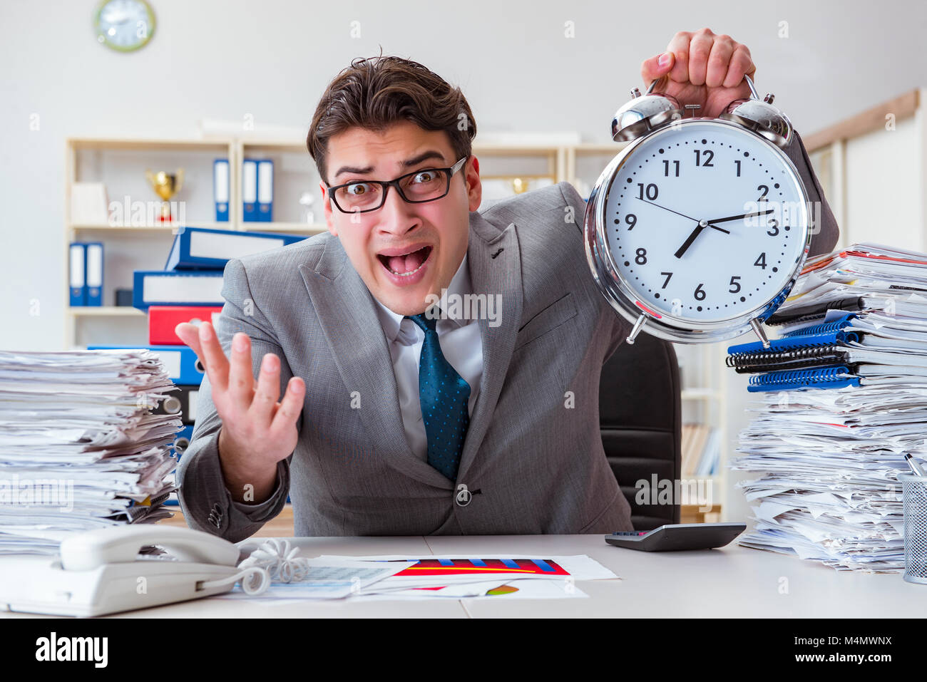 Businessman missing deadlines due to excessive work Stock Photo - Alamy