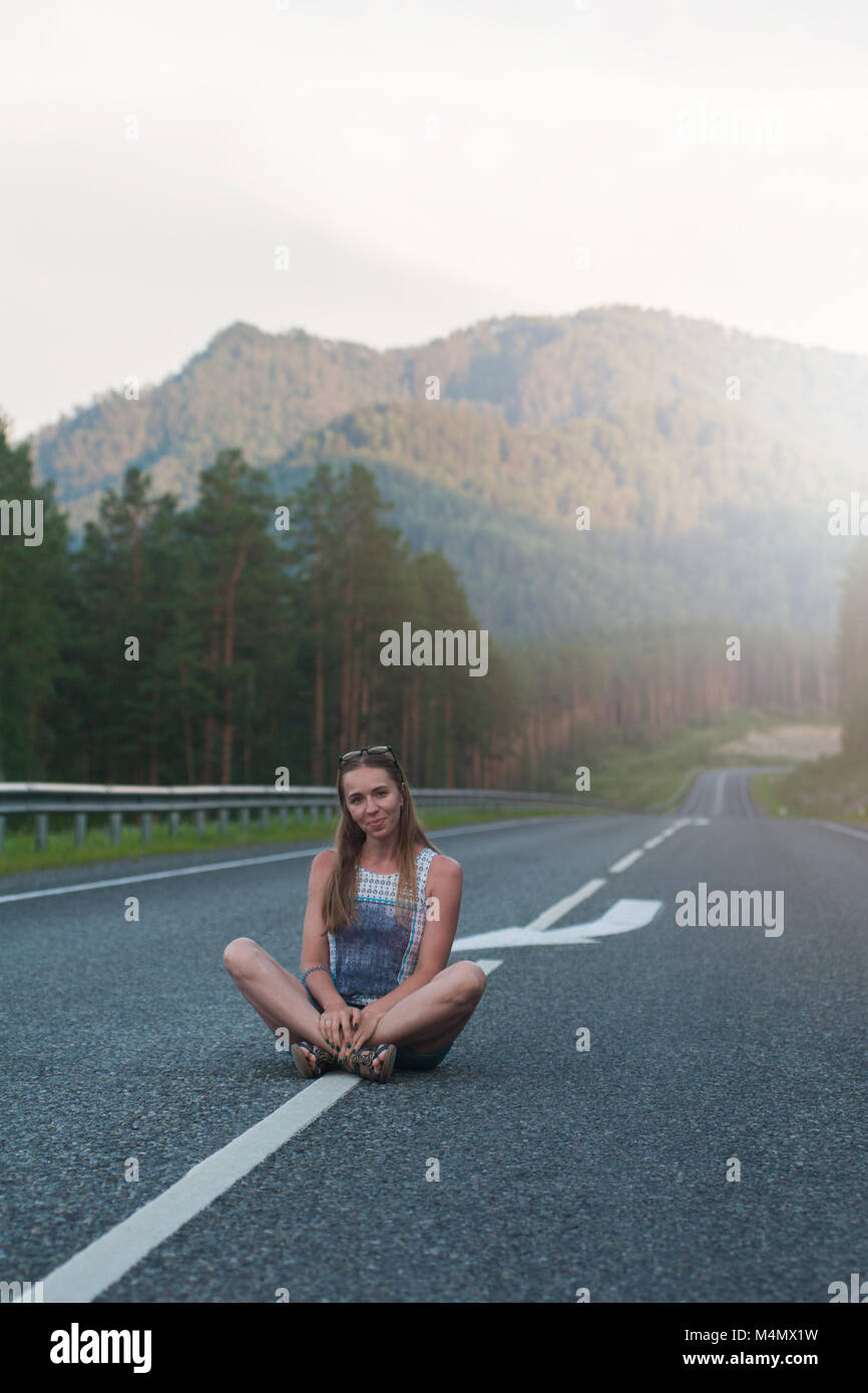 Woman sitting on the road Stock Photo - Alamy