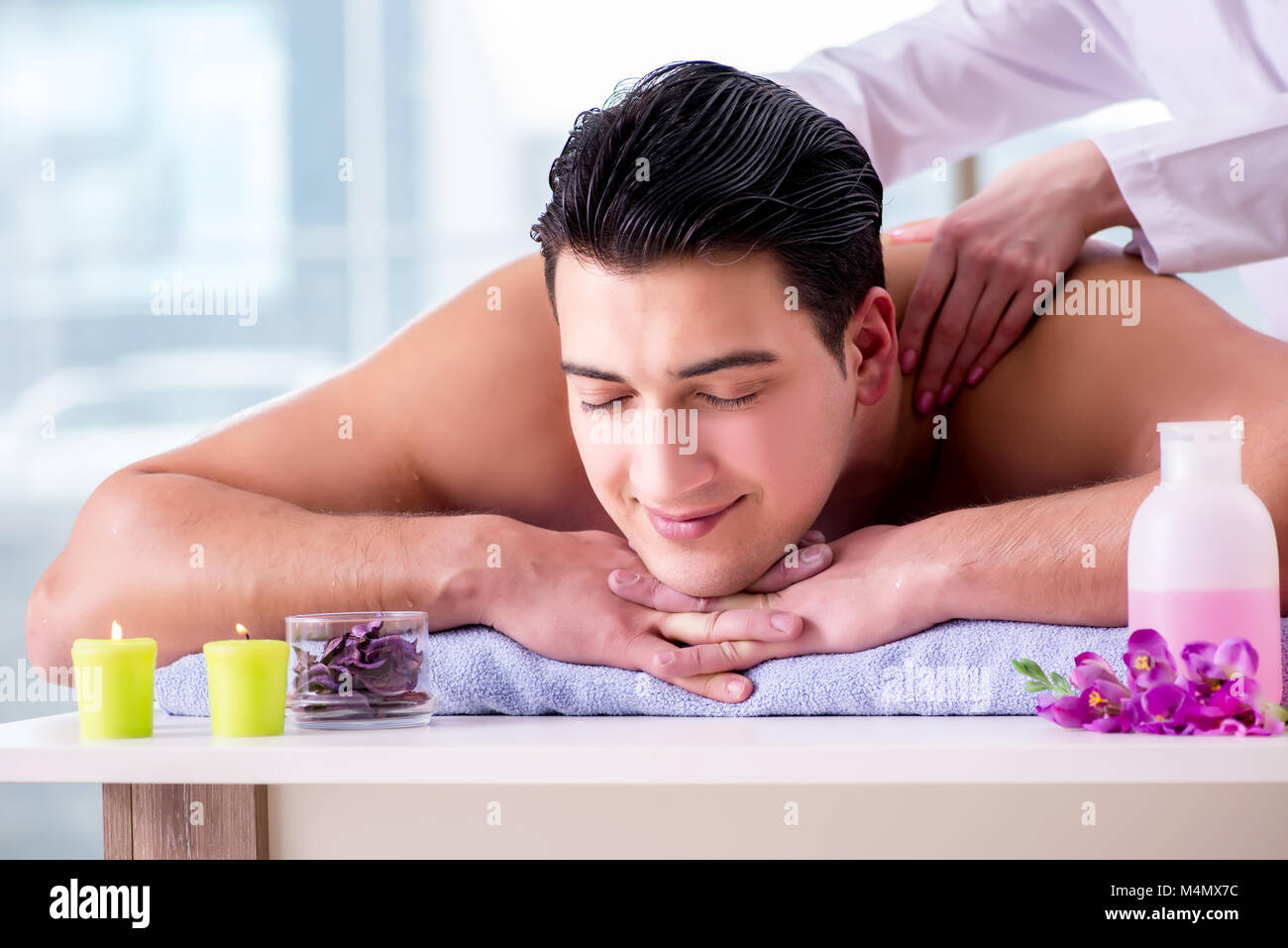 Handsome man in spa massage concept Stock Photo - Alamy