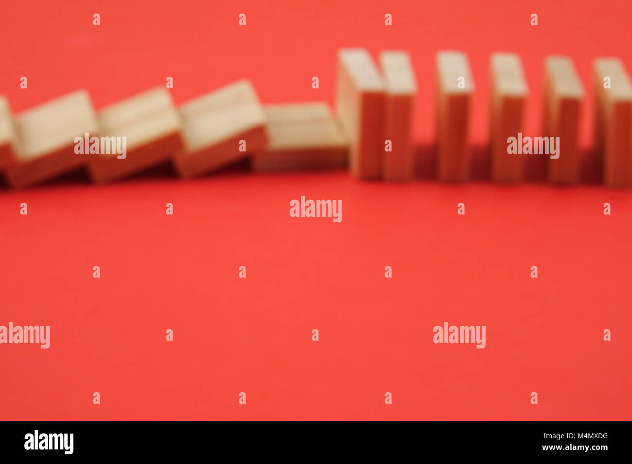 Domino effect isolated on red background. Selective focus Stock Photo ...
