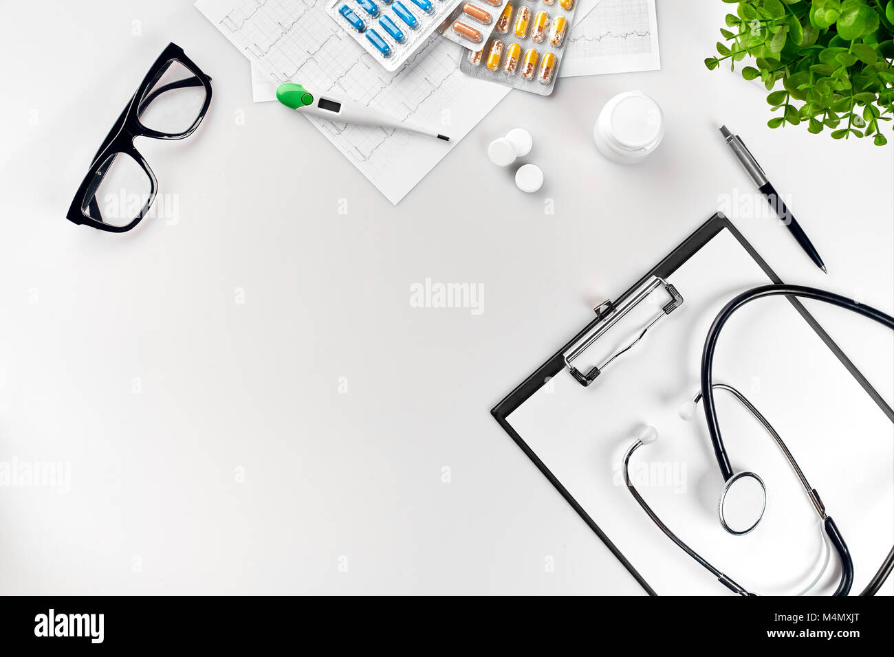Doctor's office desk with medical documents, charts, eyeglasses and ...