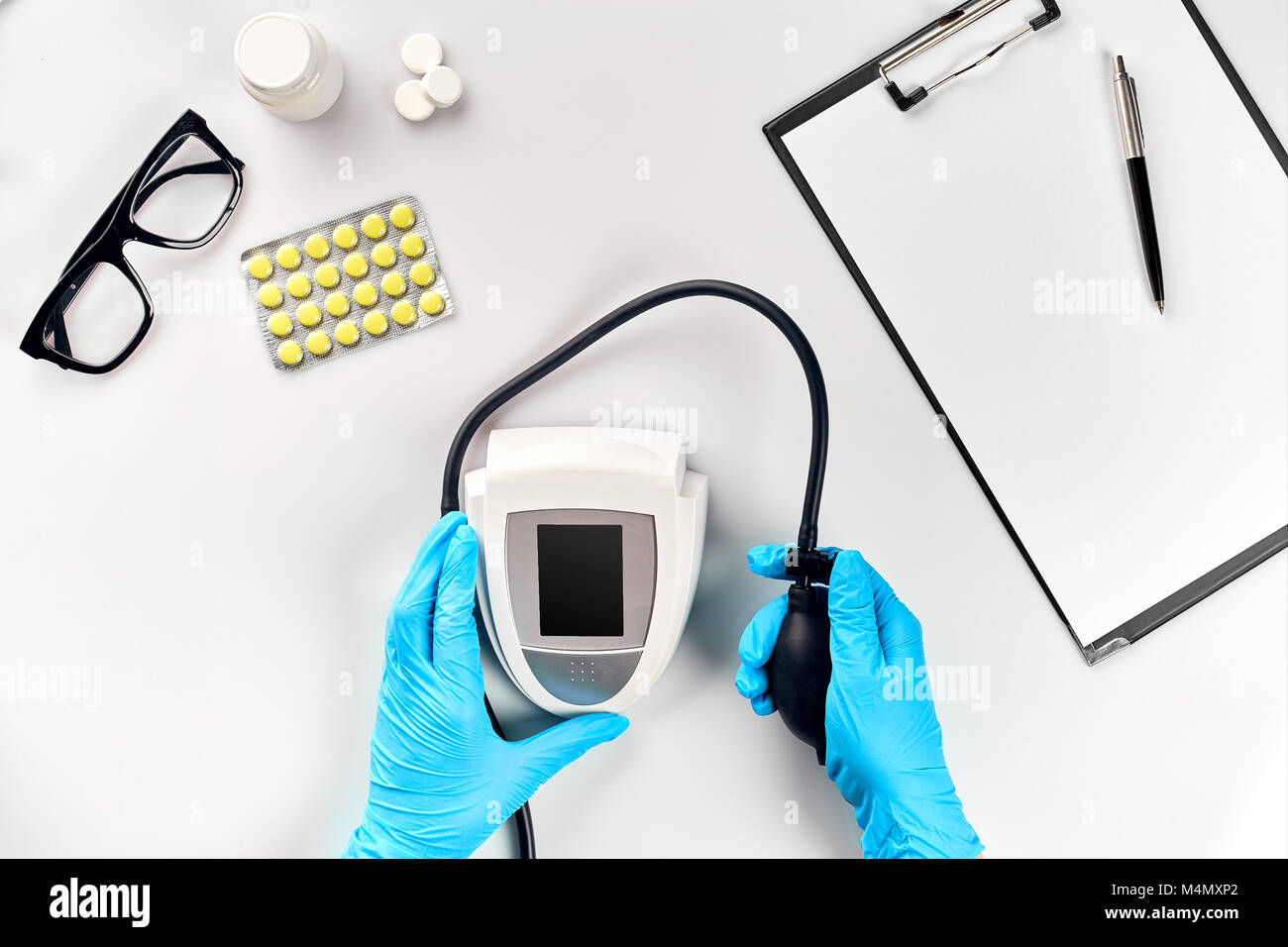 White electric tonometer on white table for measuring blood pressure ...