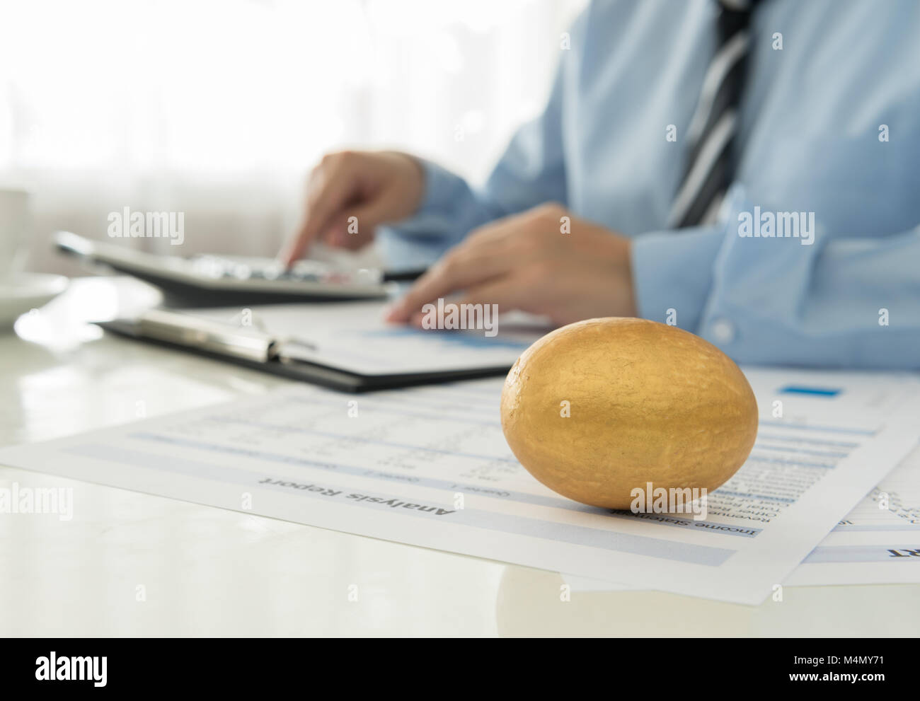 closeup golden eggs on desk in office. finance concept Stock Photo - Alamy