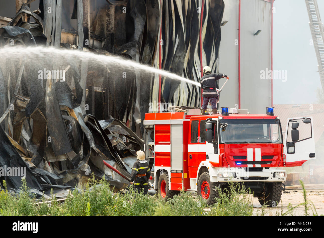Fire disaster in a warehouse. Fire fighting in an industrial area. Red ...