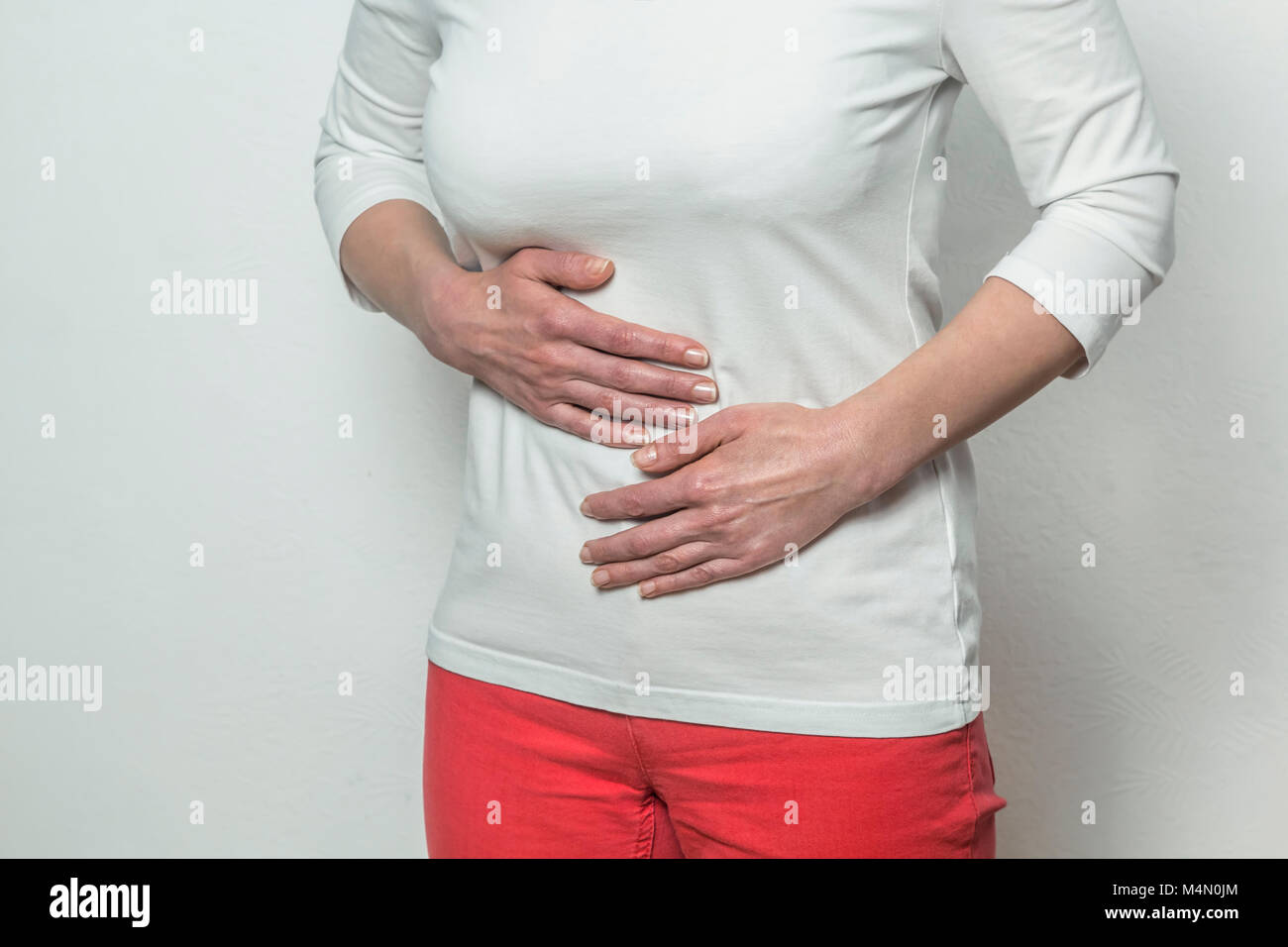 A woman holds her hands on her belly. periods Stock Photo - Alamy