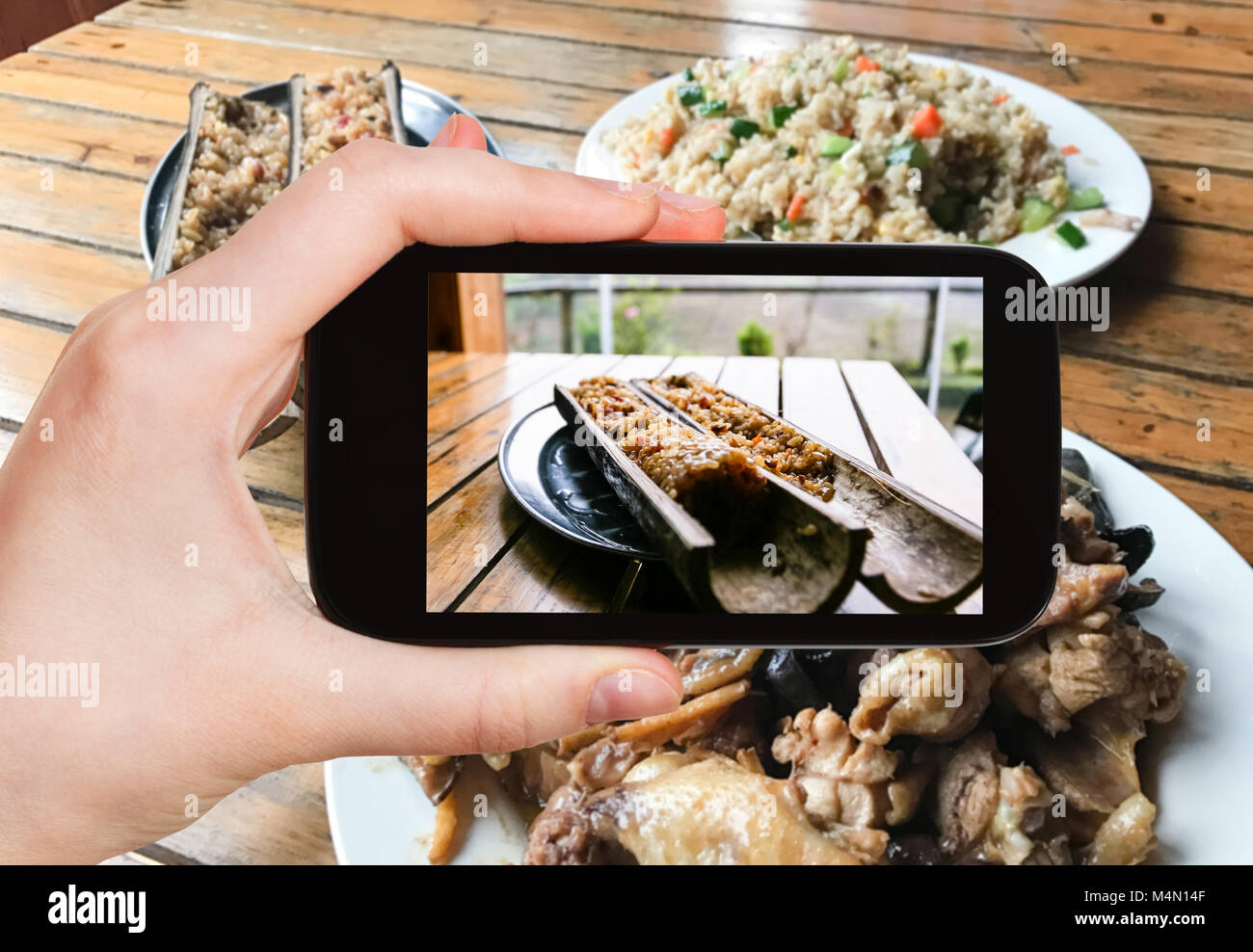travel concept - tourist photographs local chinese fried rice in bamboo ...