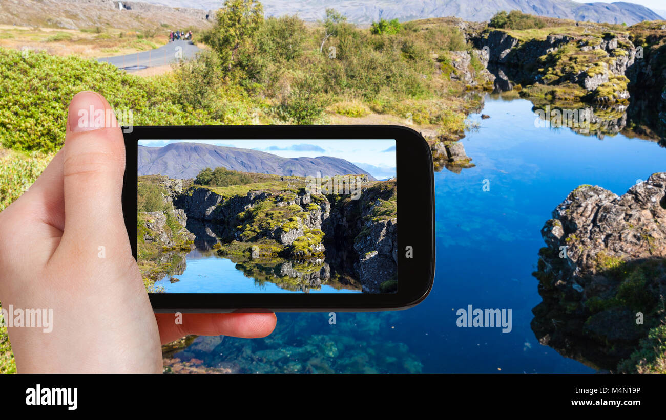 travel concept - tourist photographs Silfra fissure in rift valley of ...