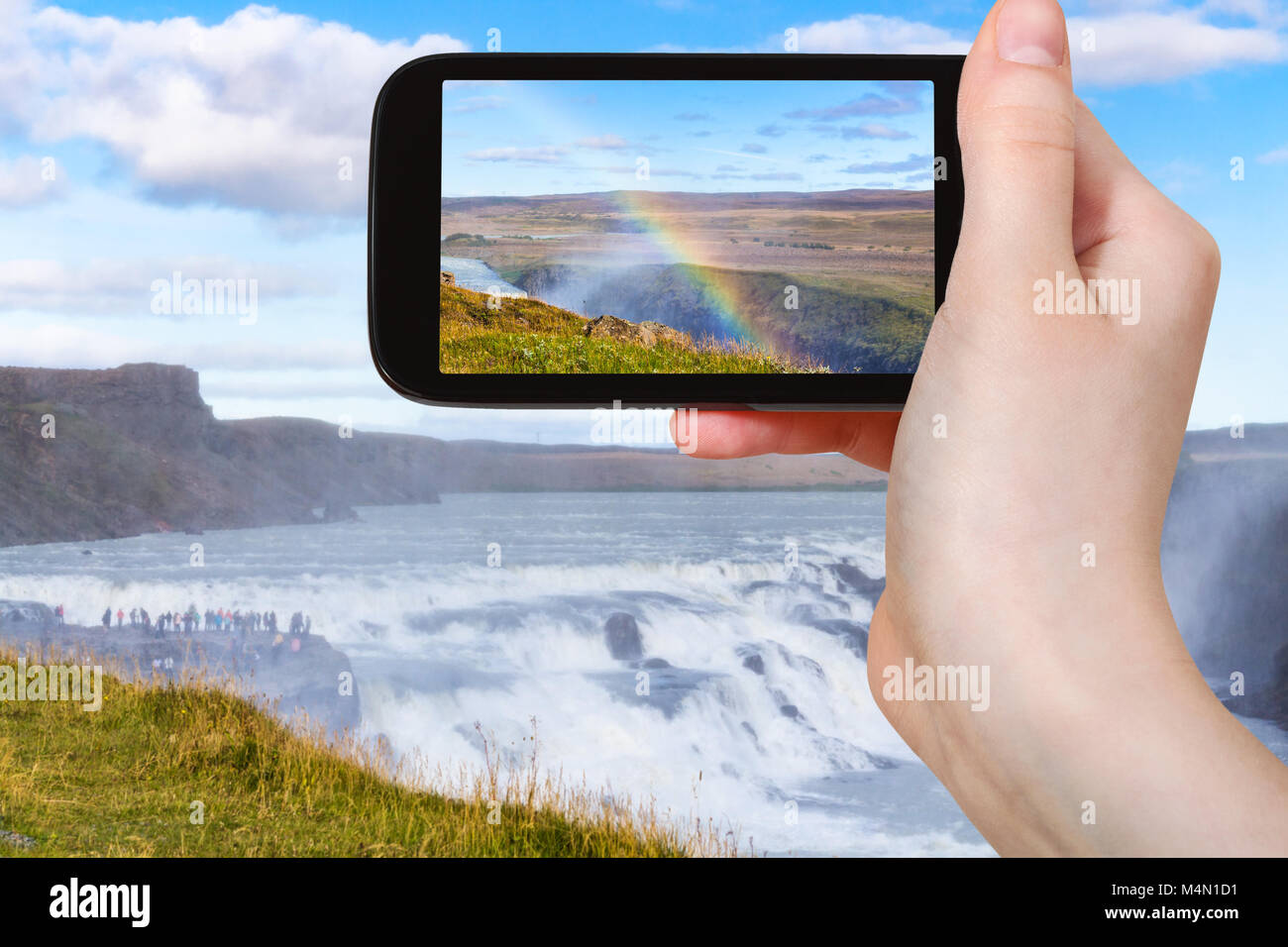 travel concept - tourist photographs rainbow over Gullfoss waterfall on ...