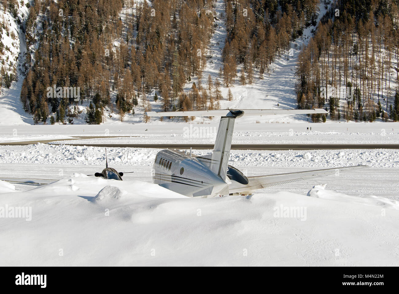 Rear view of a private jet in the snow covered airport in the alps ...