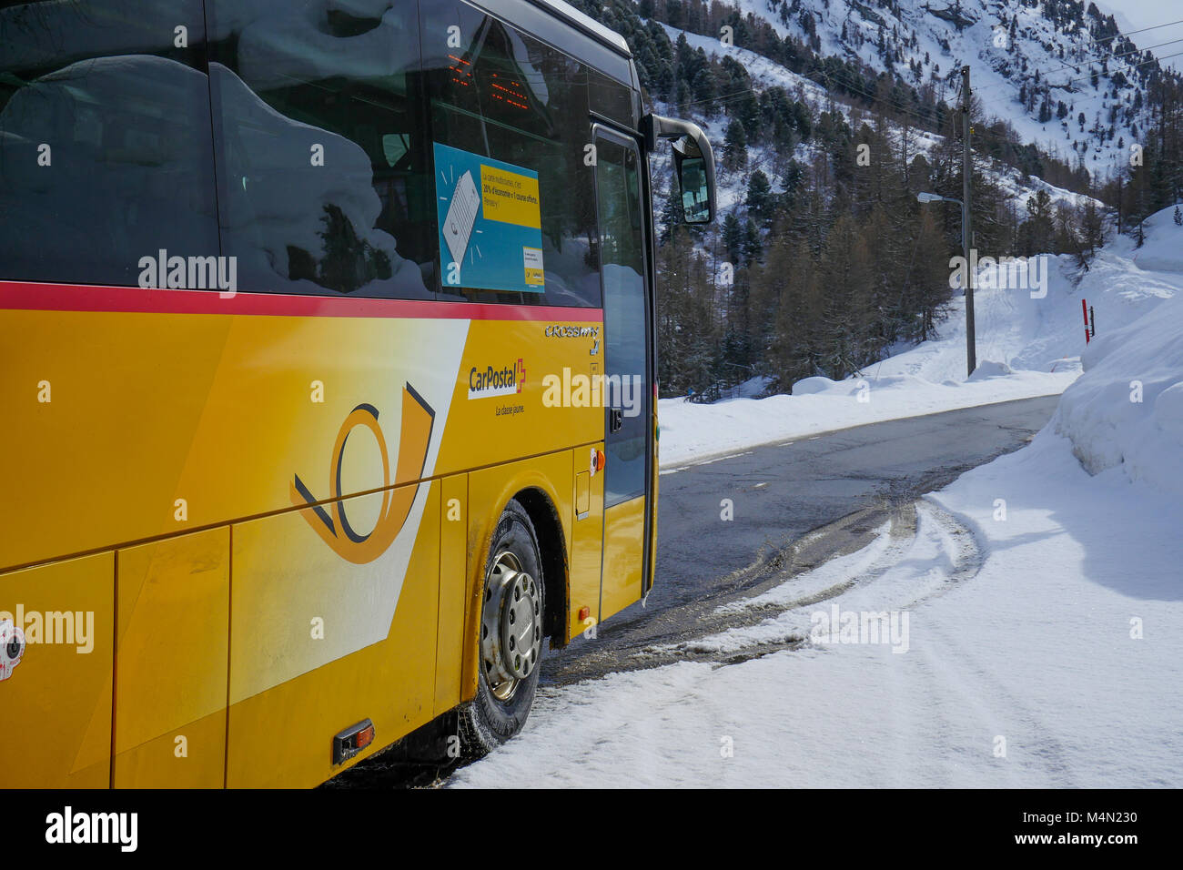 Swiss Post bus driving on a snowy mountain road, Val d'Herens, Valais ...