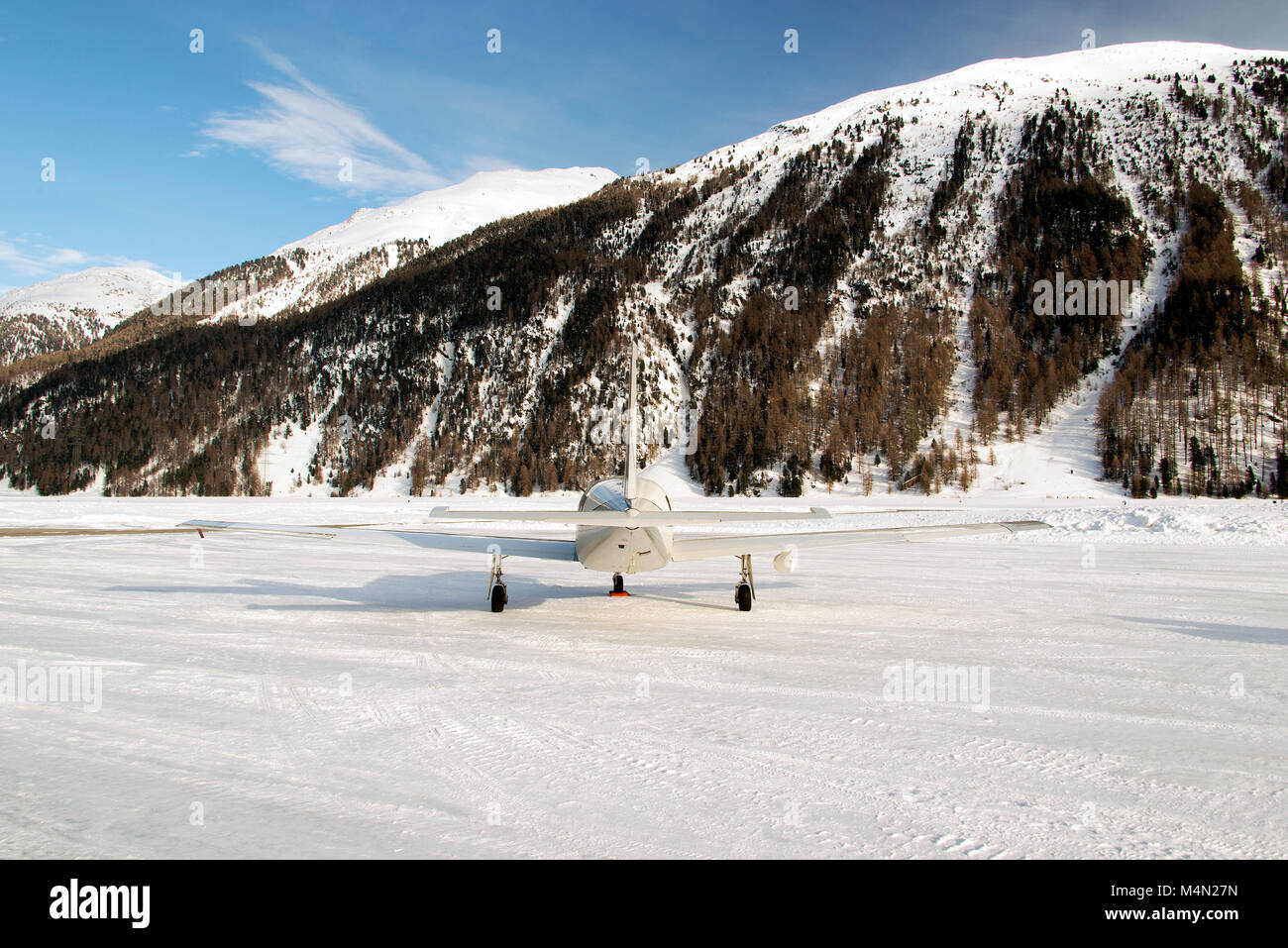 Rear view of a private jet in the snow covered airport in the alps ...