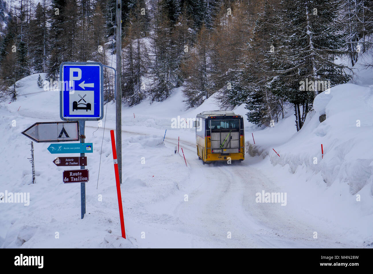 Swiss Post bus driving on a snowy mountain road, Val d'Herens, Valais ...