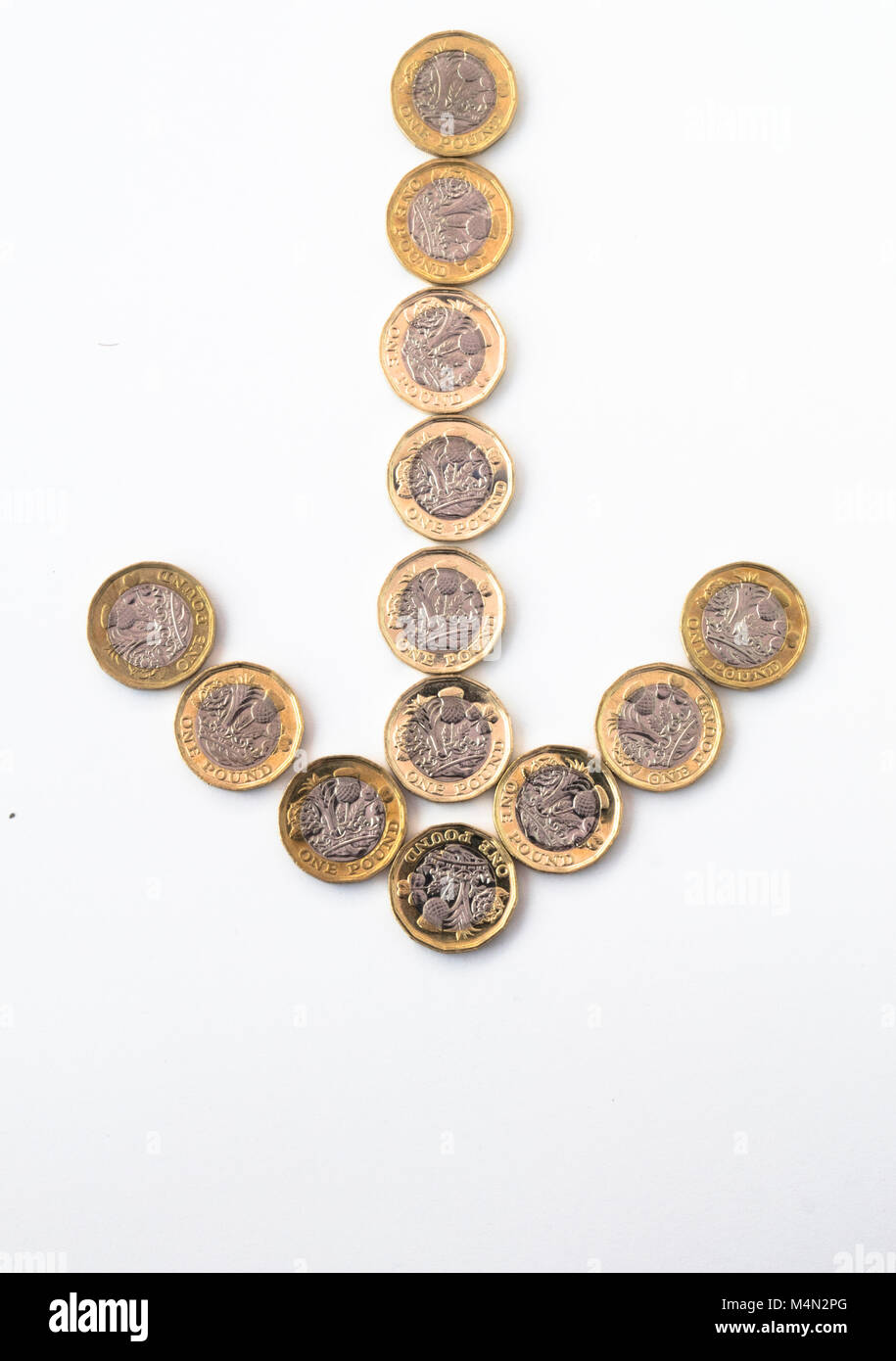 New British one pound coins arranged to form the shape of a downward ...