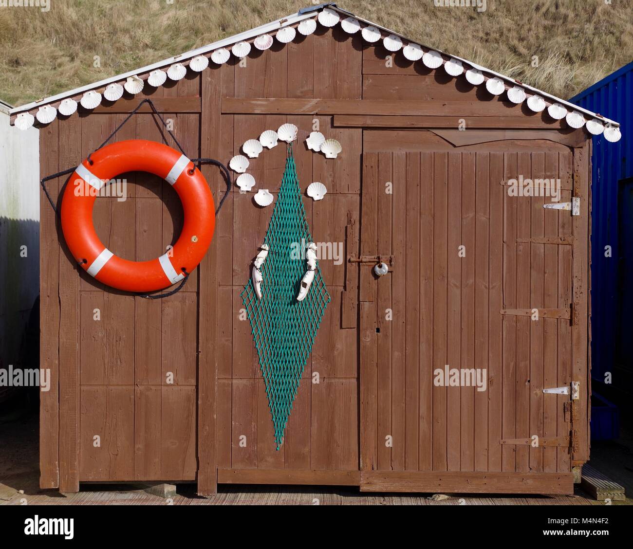 Brown Beach Hut Shed, Adorned with Scallop Pectin Shells, a Life Ring ...