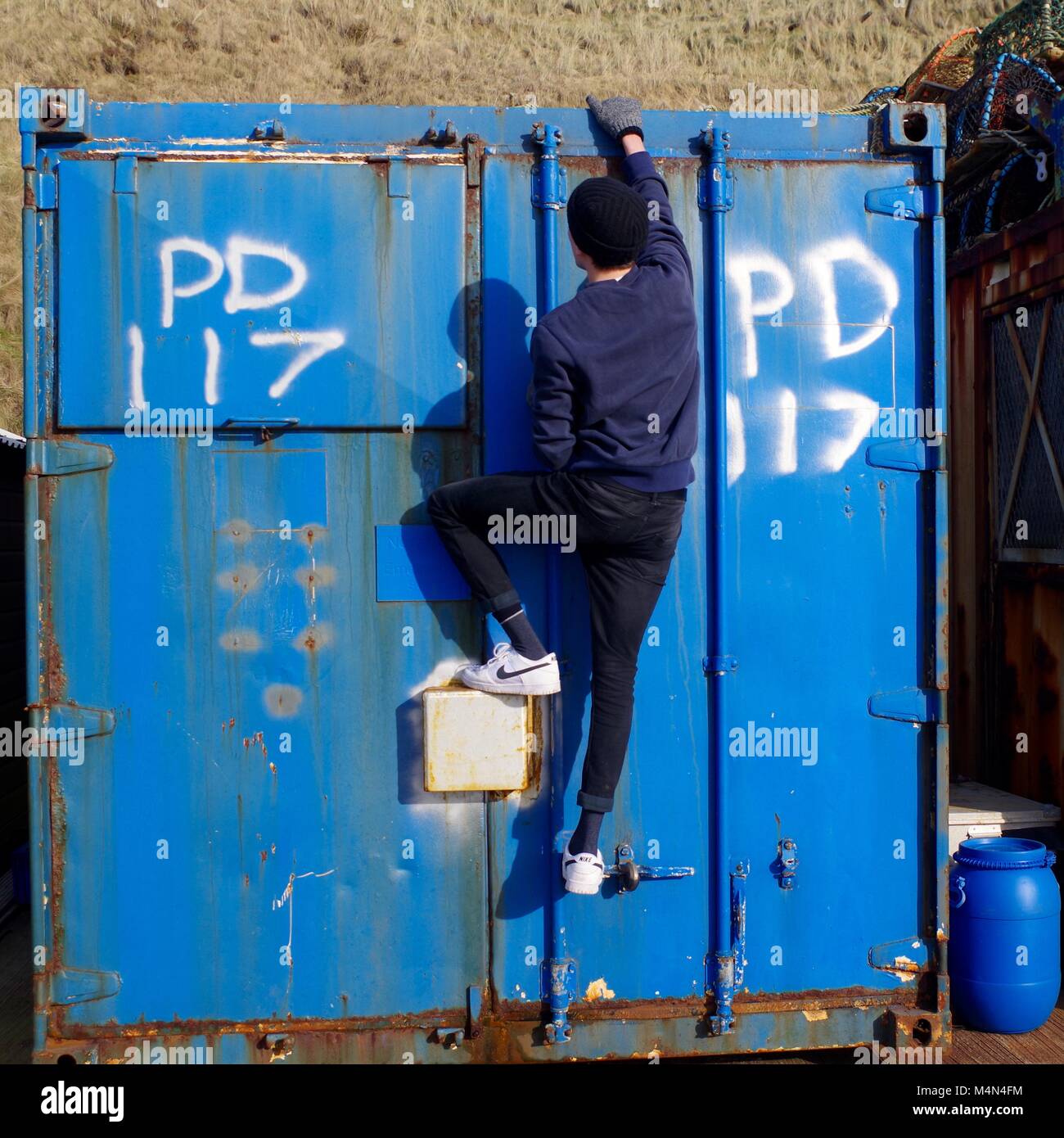 Young Man Climbing an Old Shipping Container at Cruden Bay Harbour ...