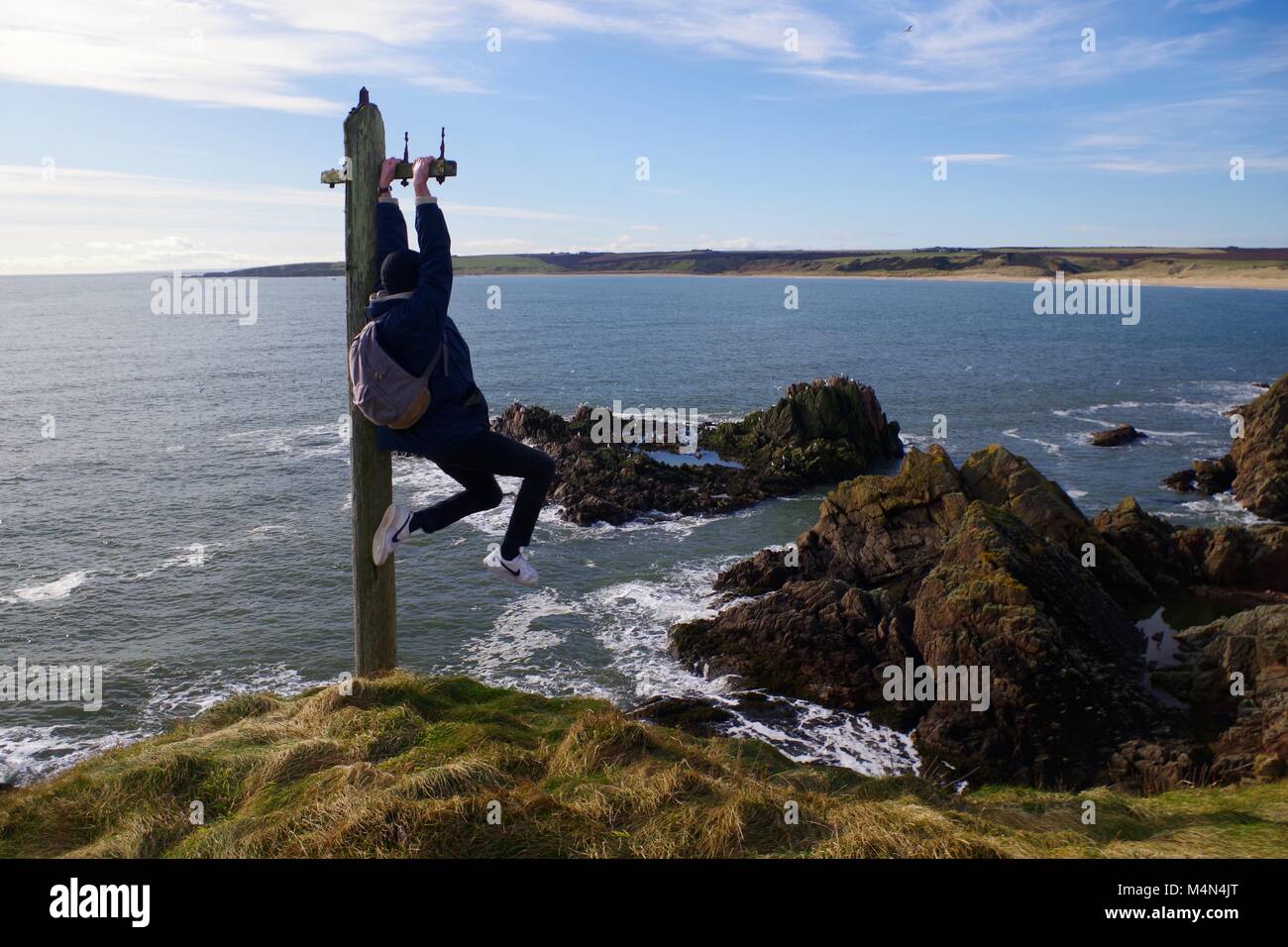 Young Adventurous Man Dangles from an Old Telegraph Pole at the Edge of ...