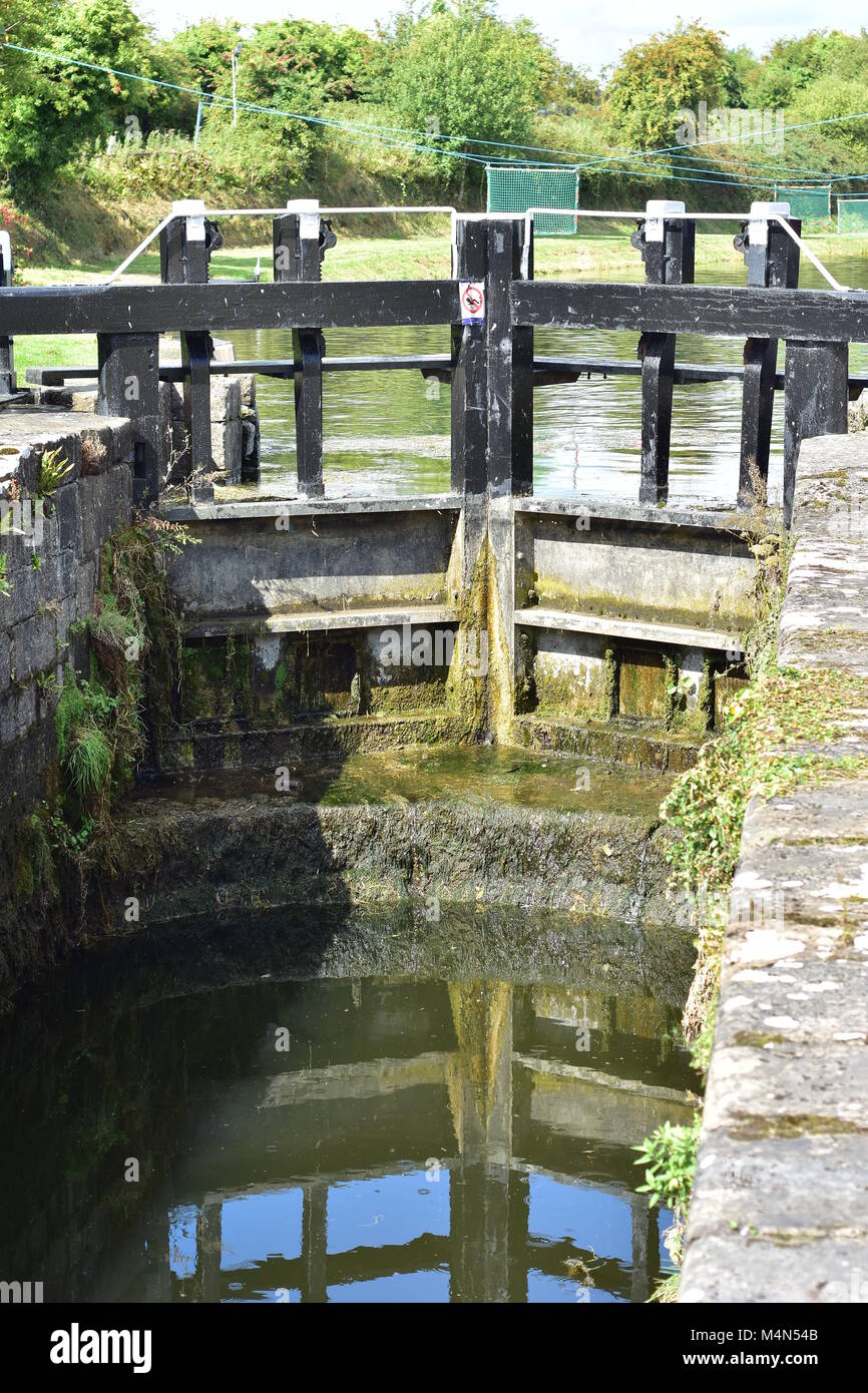 Weathered lock gate covered with green algae on Royal Canal in town of ...