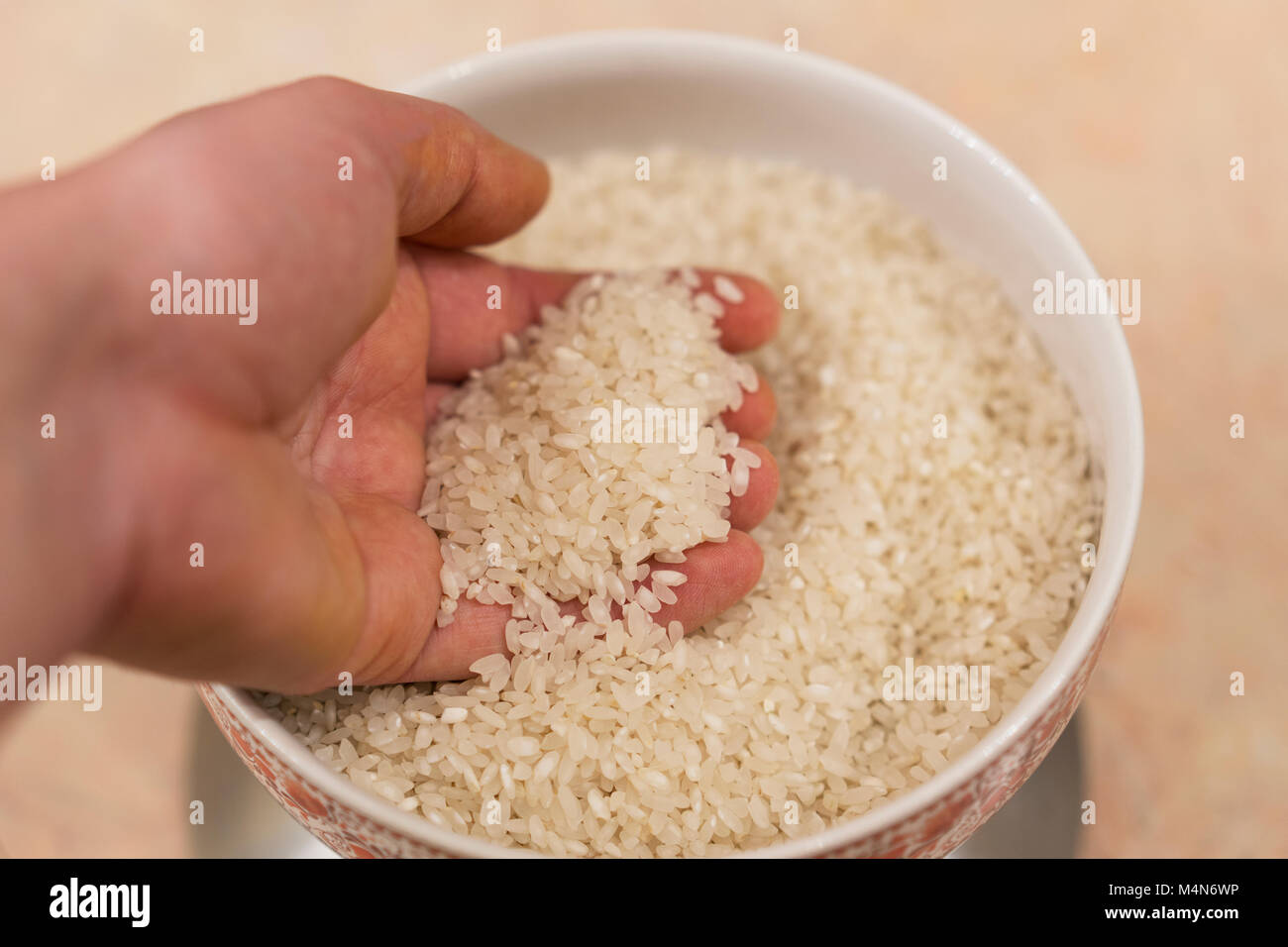 A hand takes a handful of rice. Close-up Stock Photo - Alamy