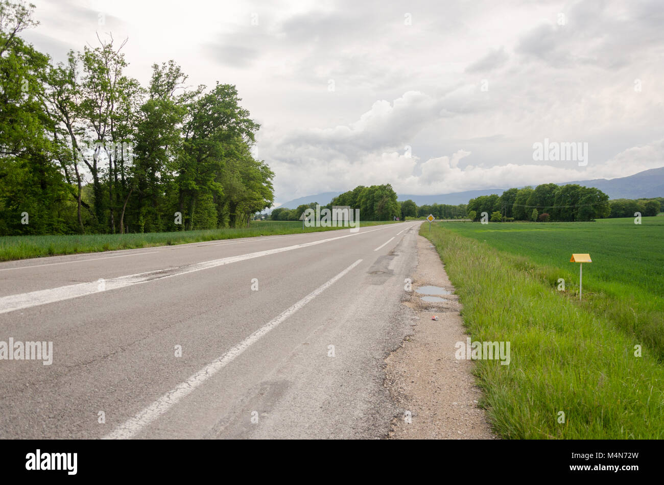 French countryside road passing straight through scenic grasslands ...