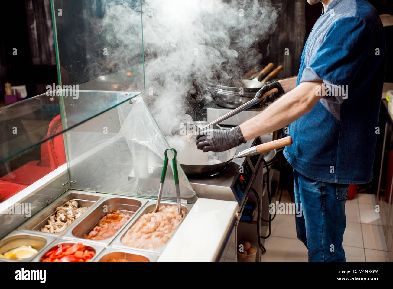 Chief cook cooking at the asian kitchen Stock Photo - Alamy