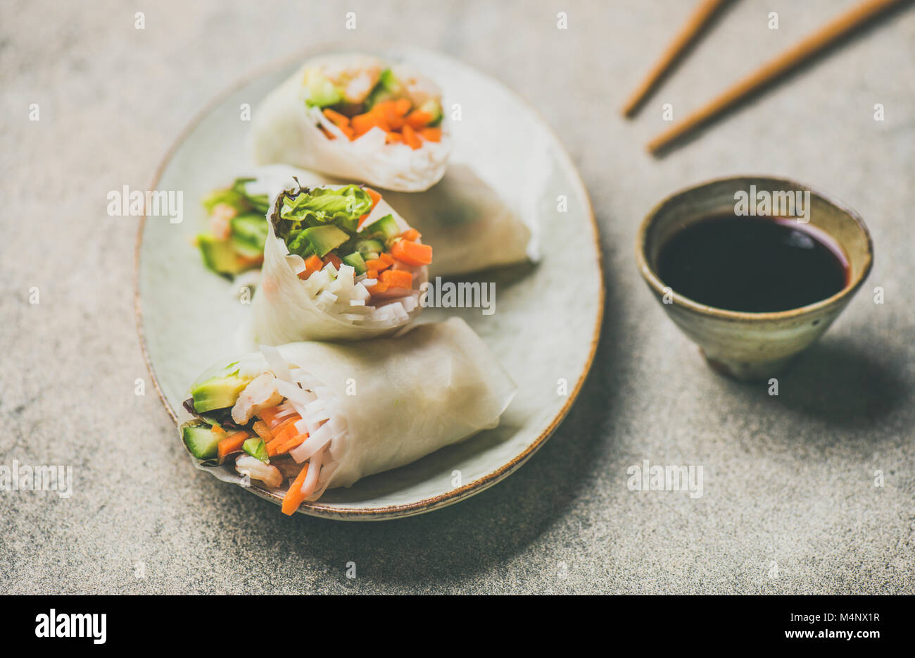 Shrimp and vegetable rice paper spring rolls with sauce and chopsticks ...