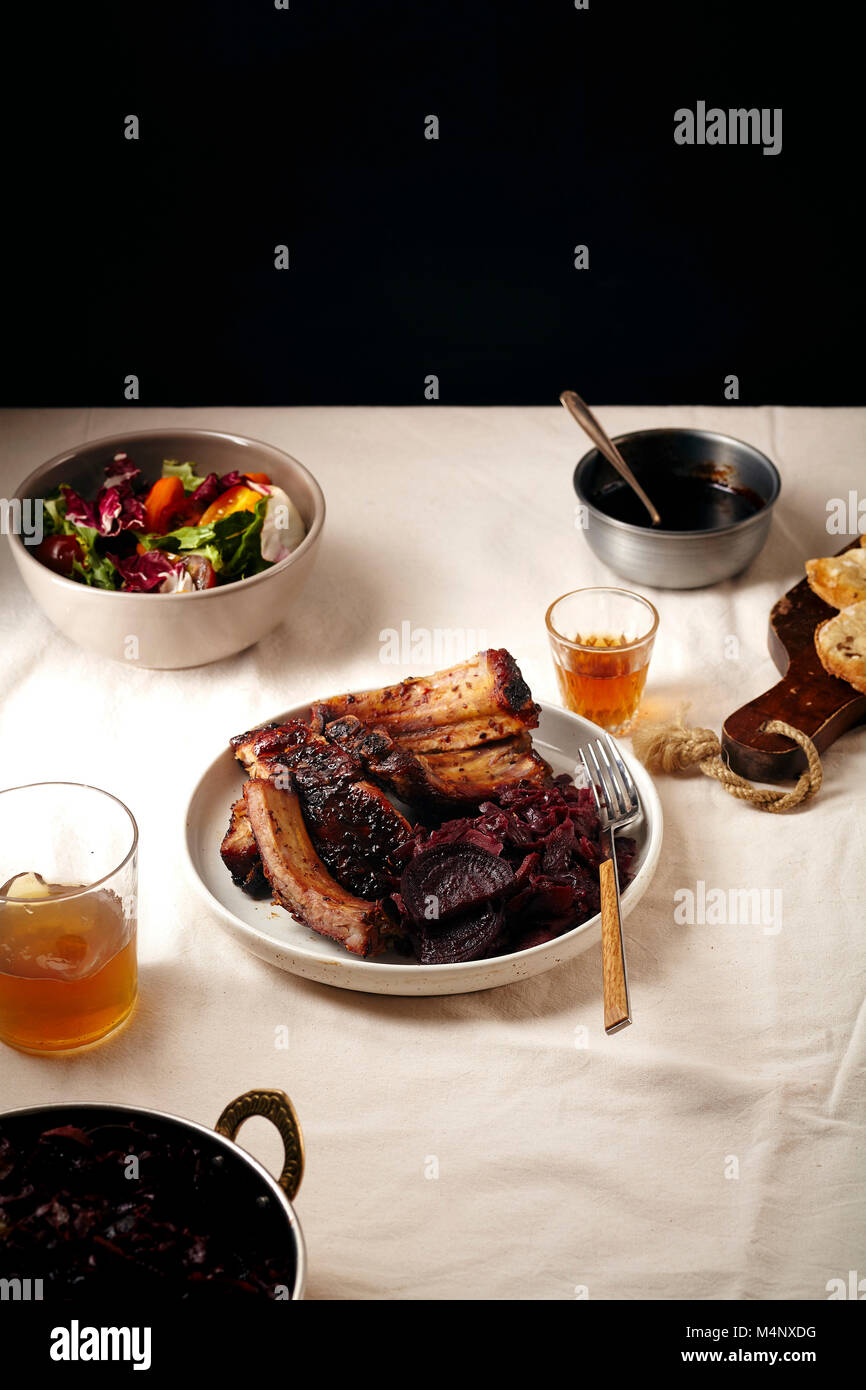 Dinner still life picture. Main dish with grilled pork ribs in thick ...