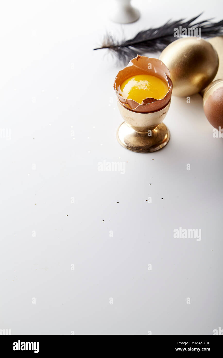 Easter holiday composition with eggs painted golden, yolk in egg stand ...